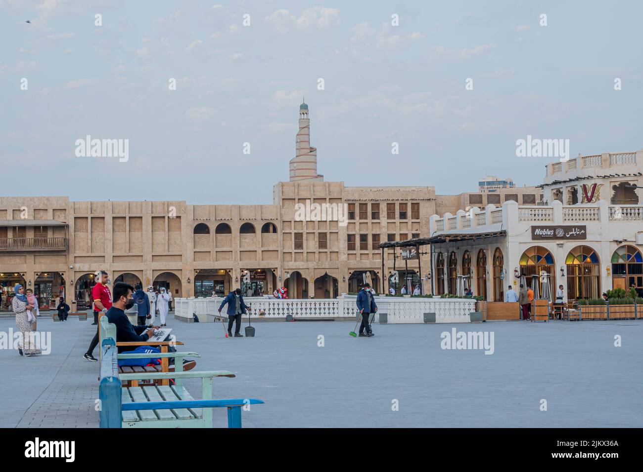 Guy sitting on a bench while sketching in Souq Waqif Doha, Qatar Stock ...