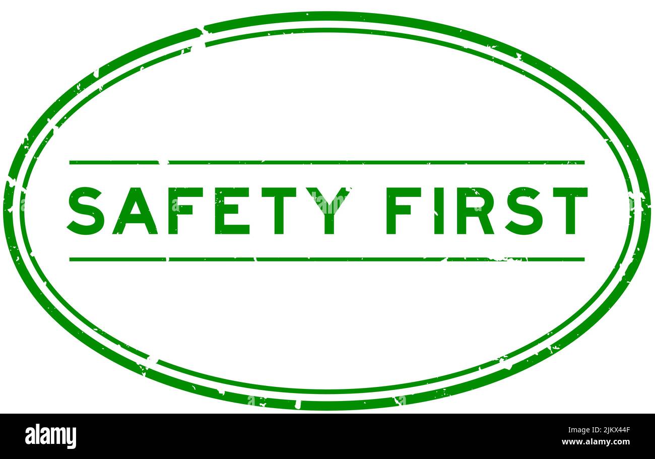 Grunge green safety first word oval rubber seal stamp on white ...