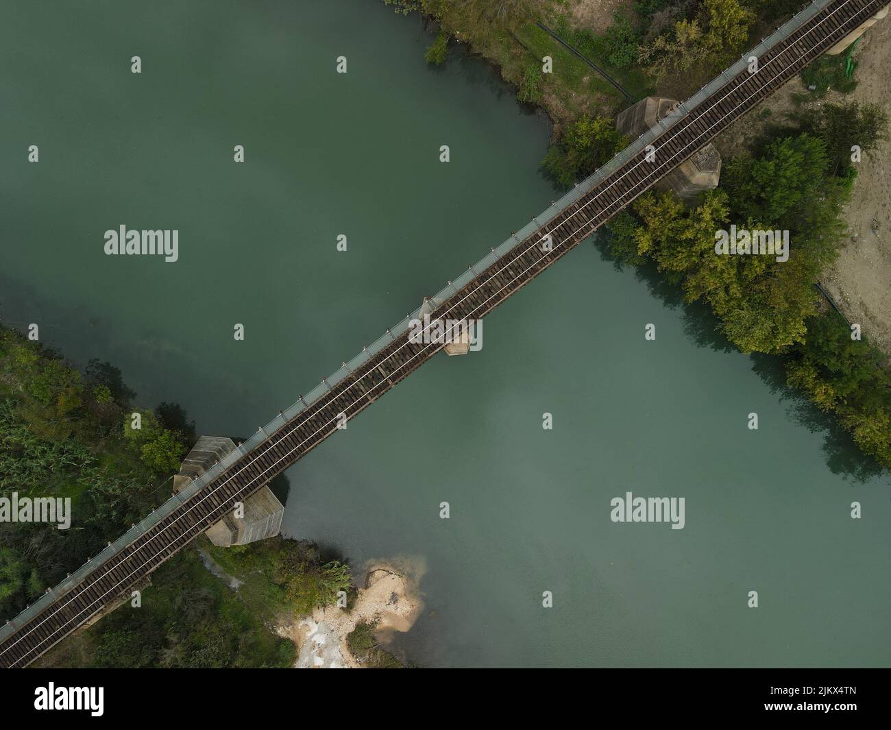 An aerial top view of a bridge above a river flowing through its banks ...