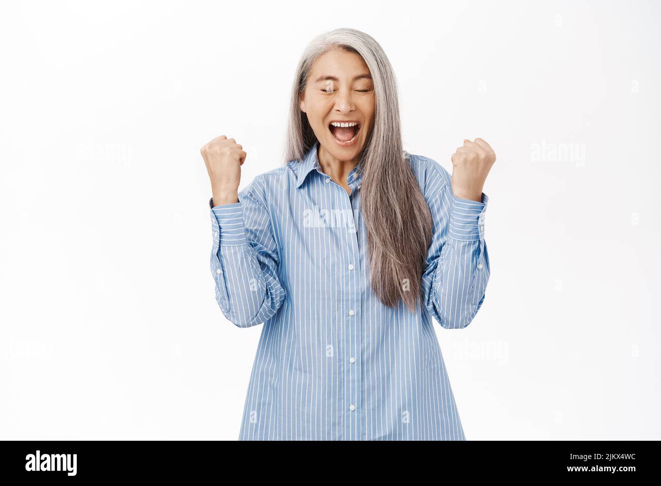 Excited senior woman shouting yes and fist pump from joy, celebrating ...