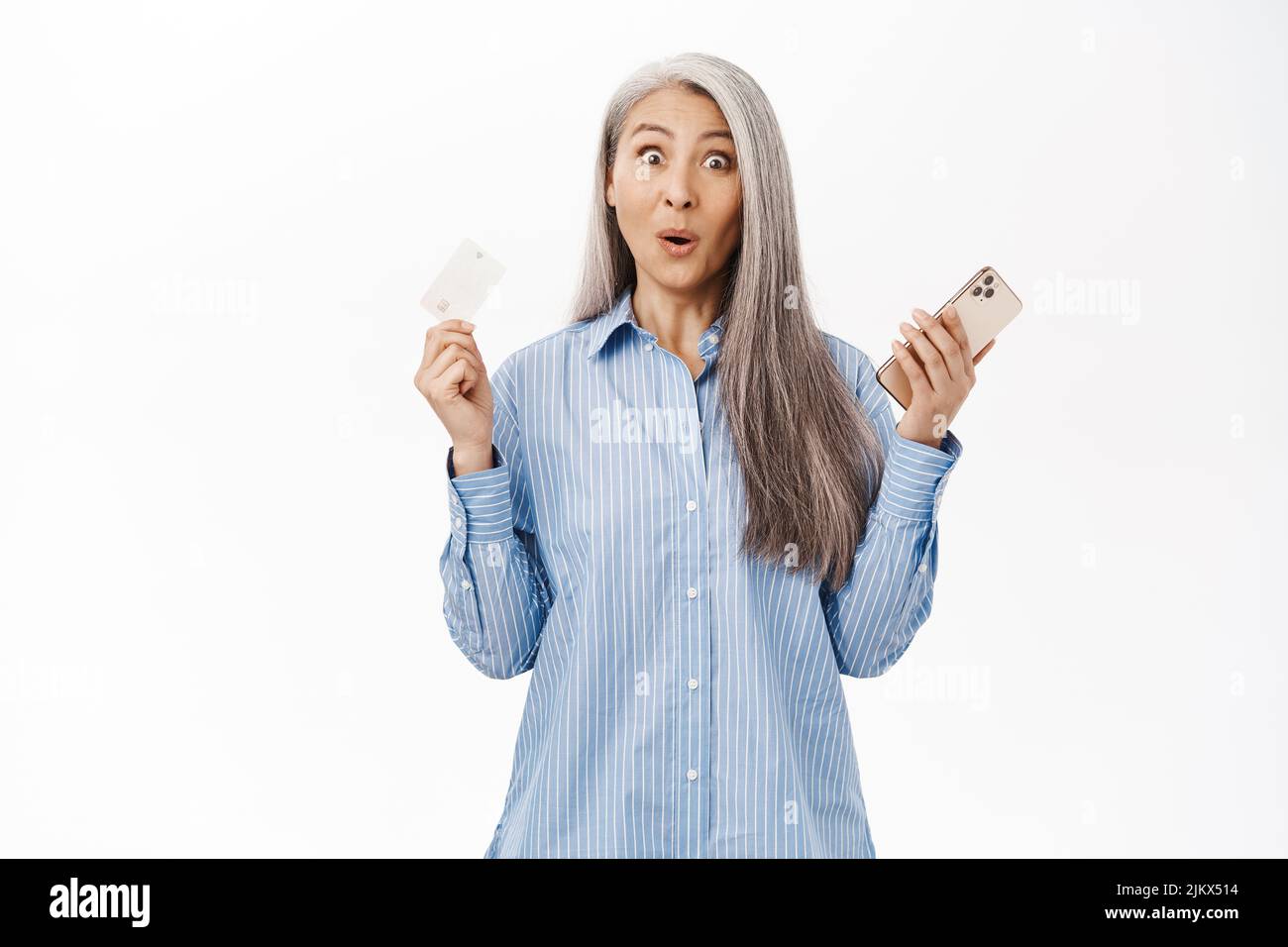 Excited asian old lady holding smartphone and rejoicing, winning online ...