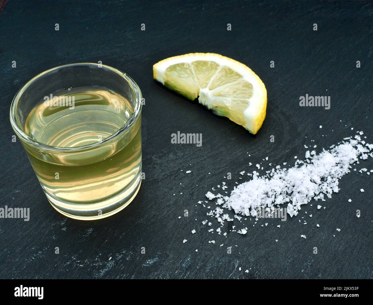 shot of tequila reposado with salt and lemon on a black slate Stock ...