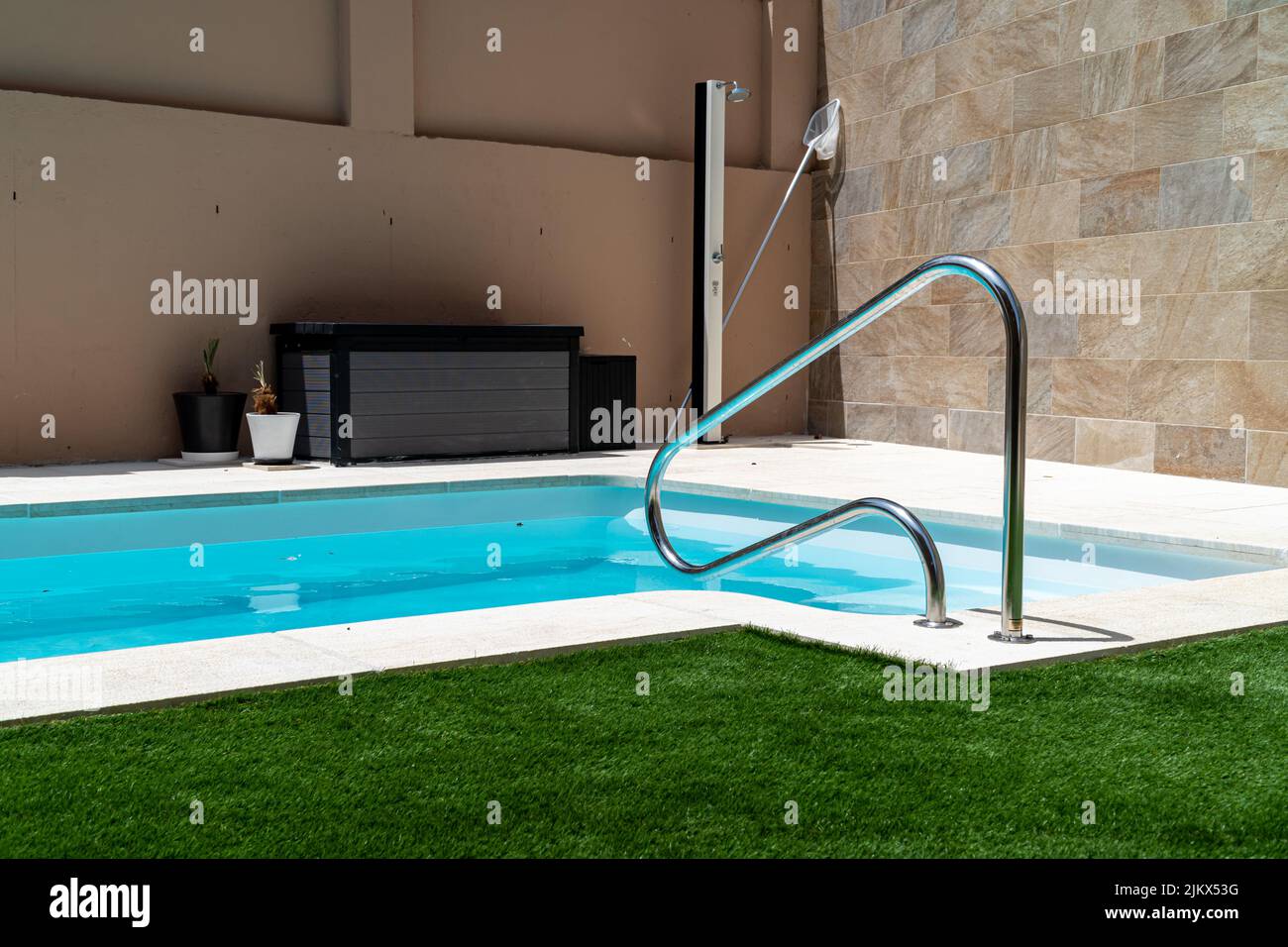 Private white garden pool, with artificial grass, a railing to enter ...