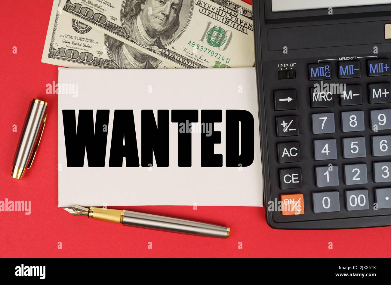 Business and finance concept. On a red background, among the money, a calculator and a pen lies ...