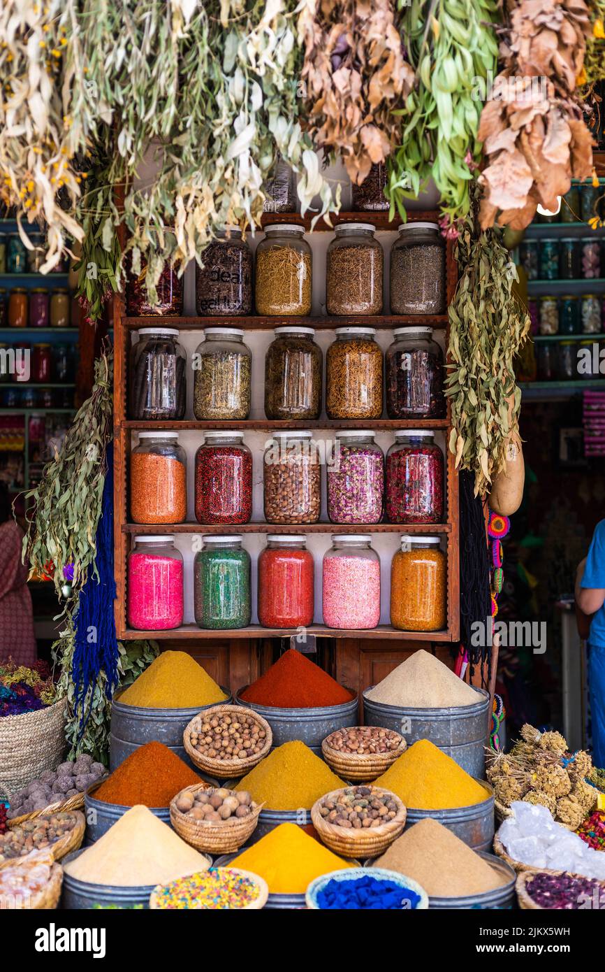 Different bright colour spices in glass recipients in a row in a spices ...