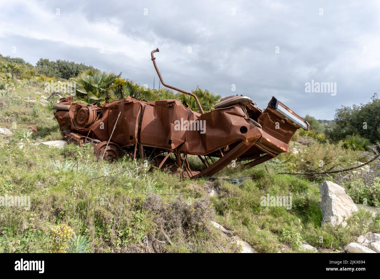 A shot of a rusty and abandoned crashed car in the mountain Stock Photo ...