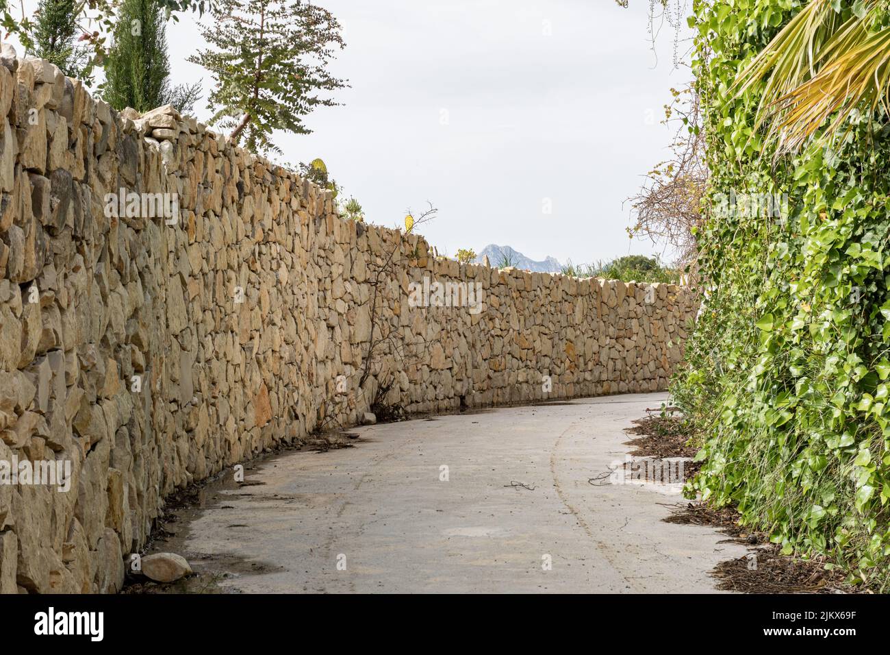 A scenic shot of a path with rock and leaves walls Stock Photo - Alamy