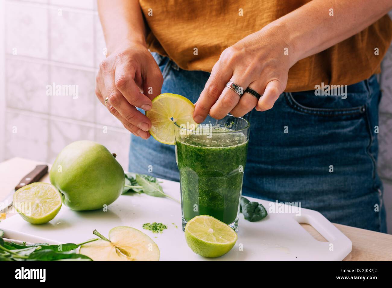 A Woman Prepares A Green Smoothie Drink From Fresh Fruits And