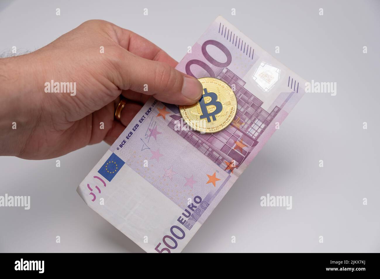 Male hand holding money. Gold bitcoin and 500 euros bank note. Gold BTC ...