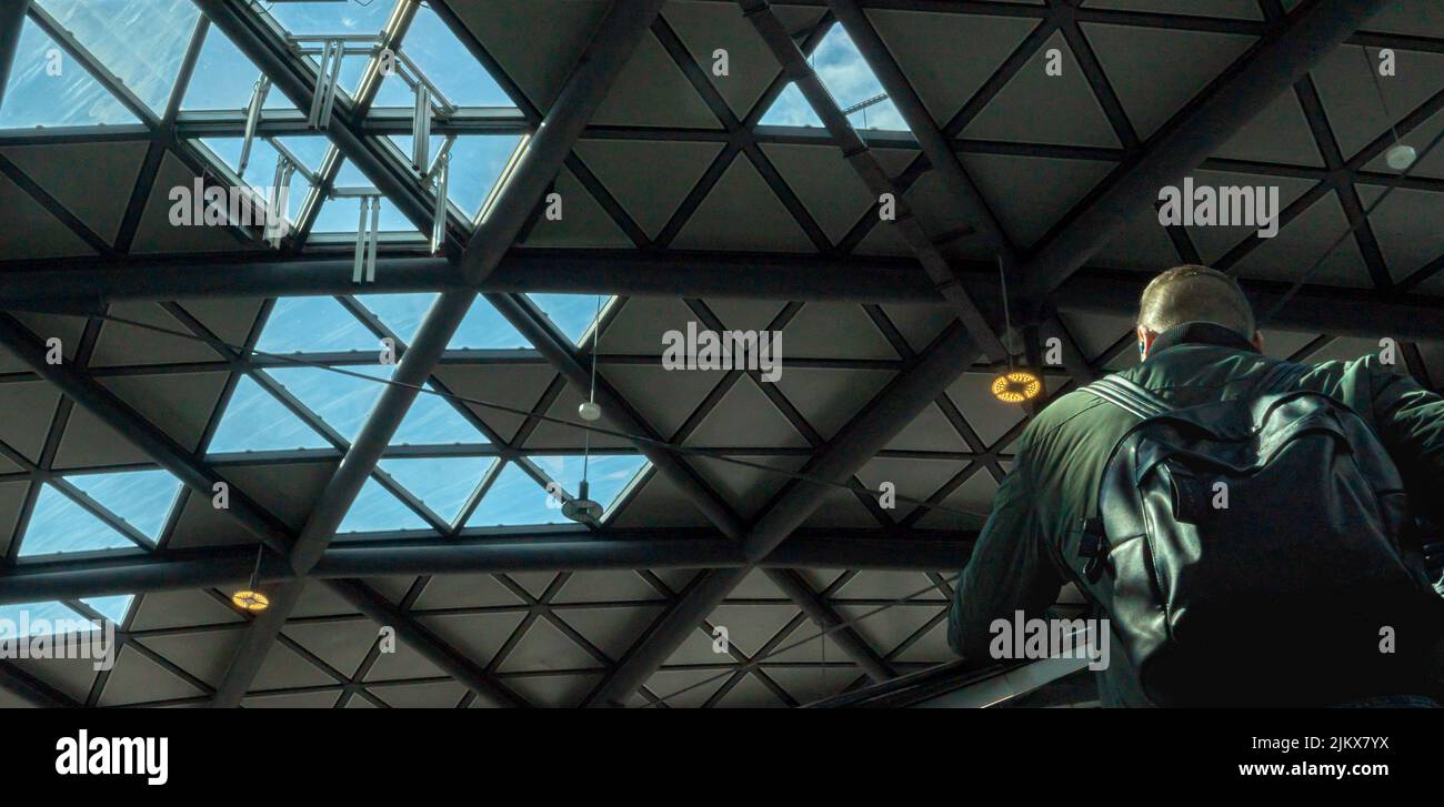 Low angle view of man from behind on elevator inside modern ...