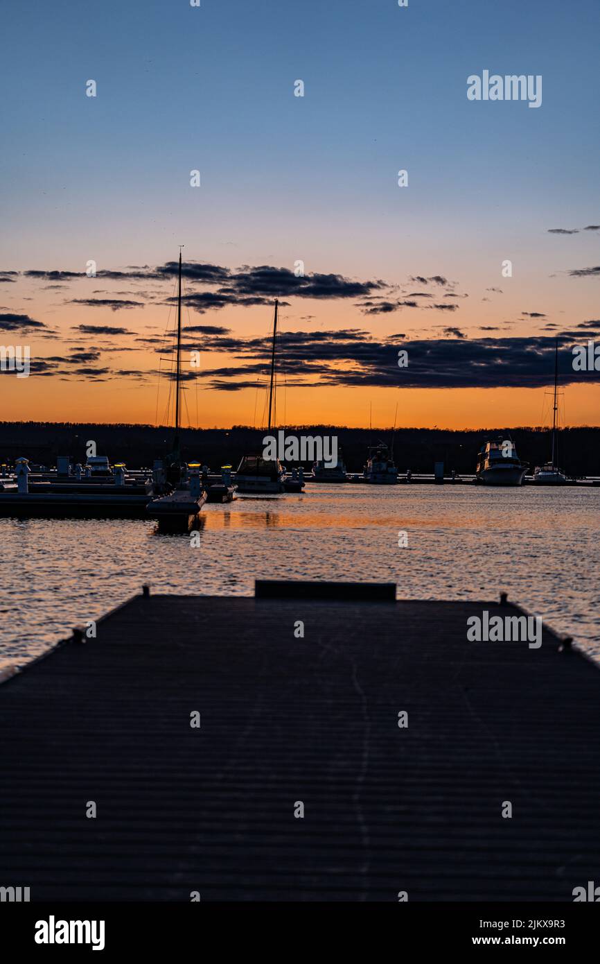A sunset view on the lake deck with ships floating and a cloudy day ...