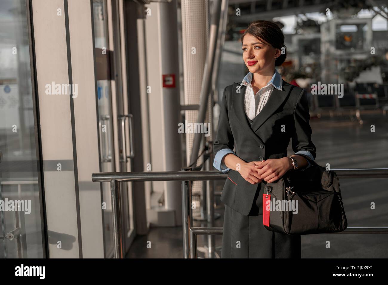 Happy beautiful female flight attendant holding bag and posing Stock ...