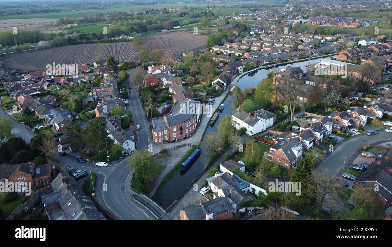 A bird's eye view of a bridge on a river in a small town with green ...