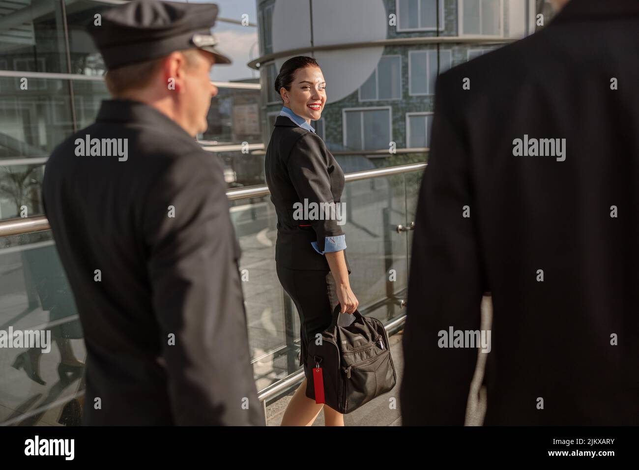 Flight attendant holding a bag and looking back at the pilots Stock ...
