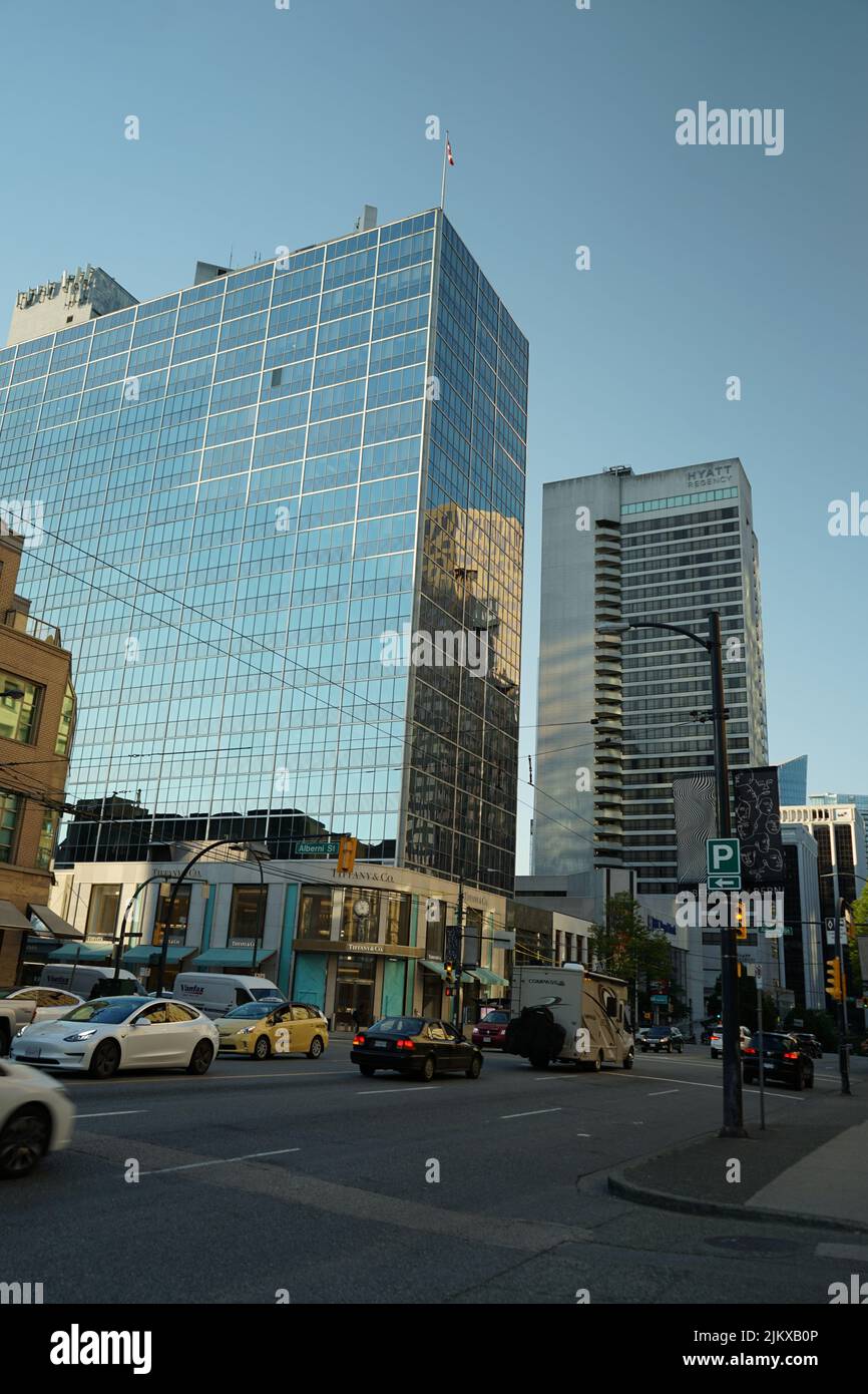 A vertical shot of tall modern buildings and a busy street in downtown ...