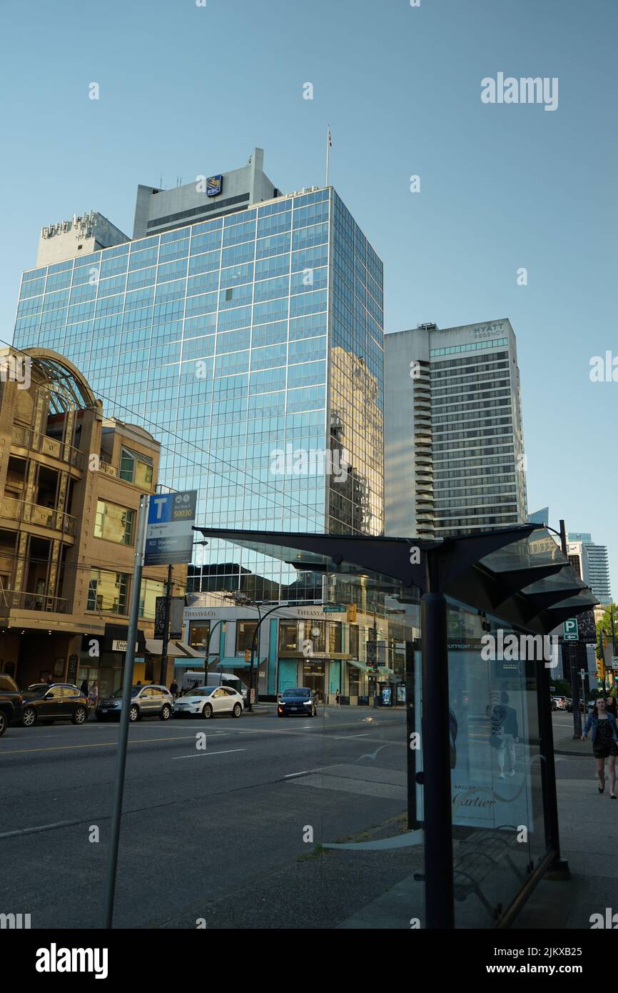 A vertical shot of tall modern buildings and a busy street in downtown ...