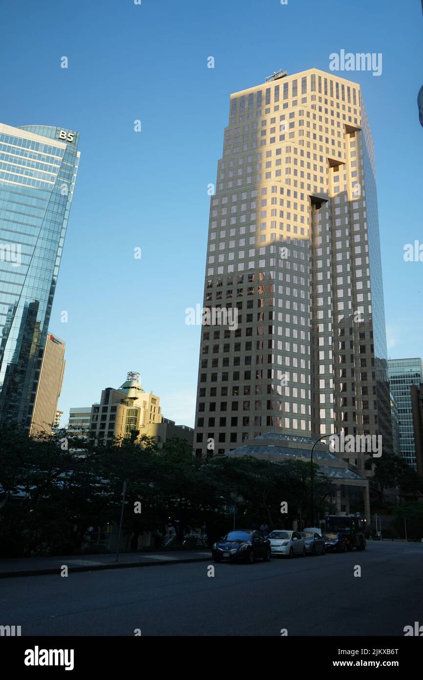 A vertical low shot of a tall skyscraper above the street with modern ...
