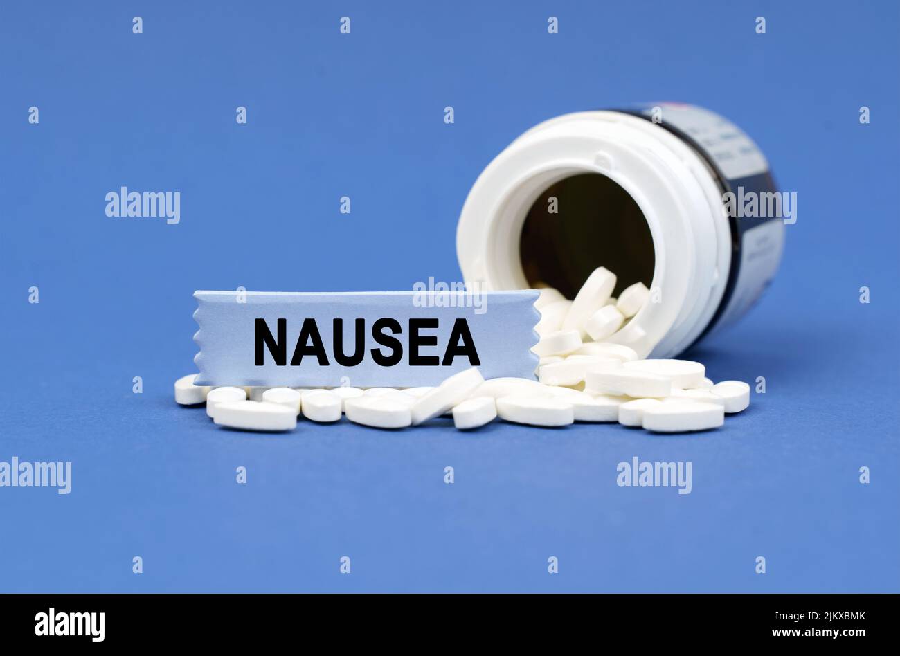 Medical concept. On a blue surface lies a jar of pills and a sign with ...