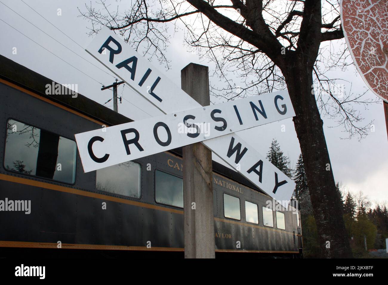 A Railway crossing sign with the train in the back in Langley, British ...