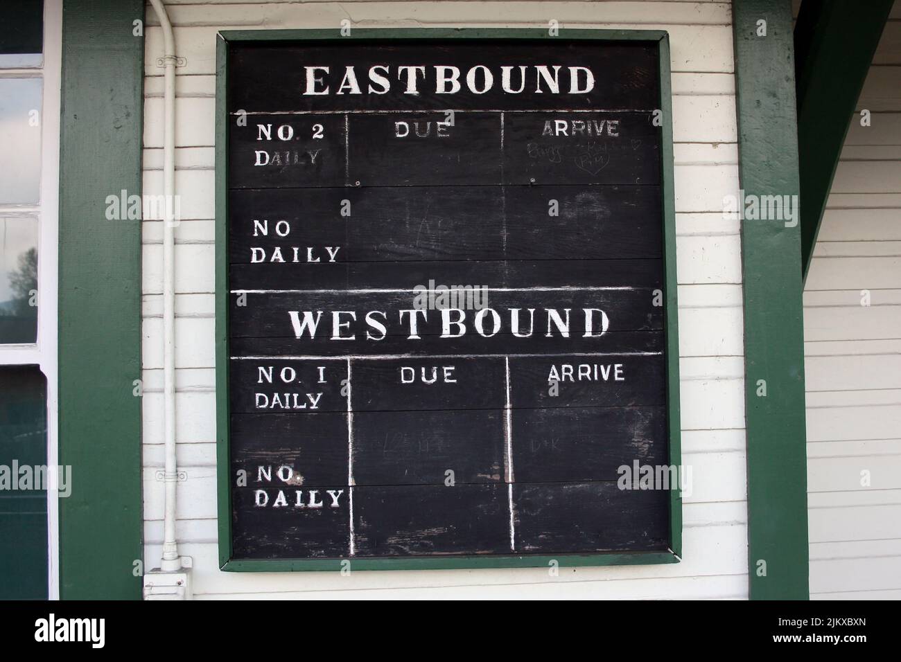 A black board on a wall of buildings with schedule of East bound and west bound Stock Photo - Alamy