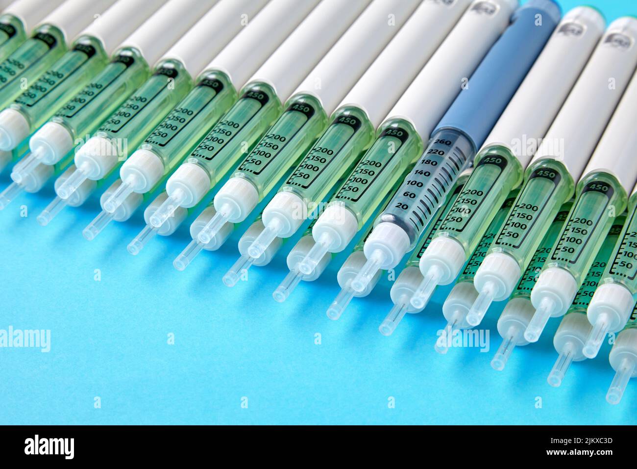 Diabetic insulin pens lined up on a blue background. Provision of ...