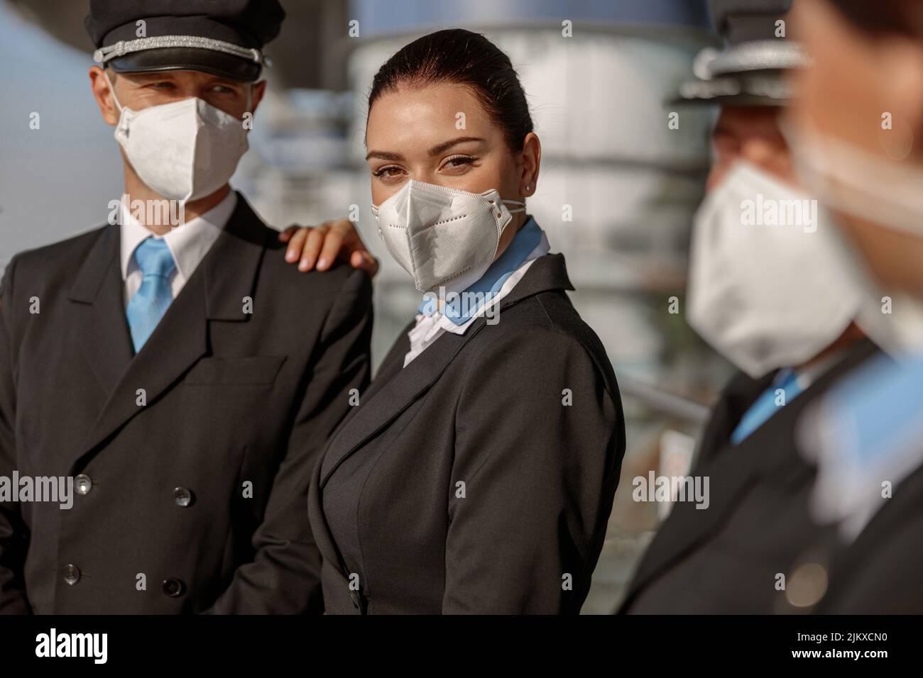 Stewardess in a mask putting her hand on the pilot shoulder Stock Photo ...