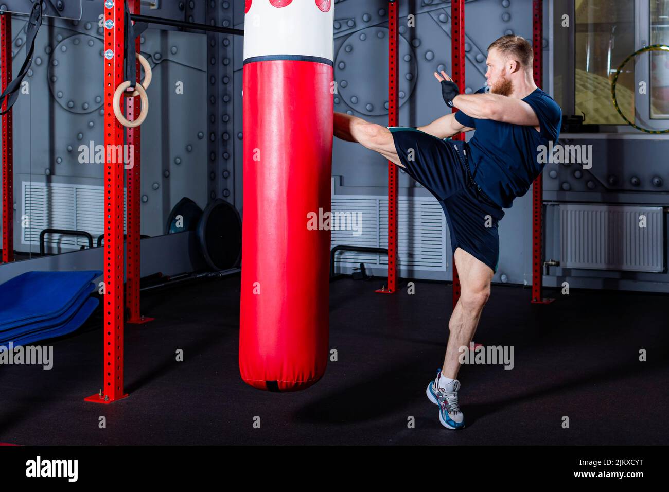 Young mixed martial arts fighter and trainer delivers strong side kick ...