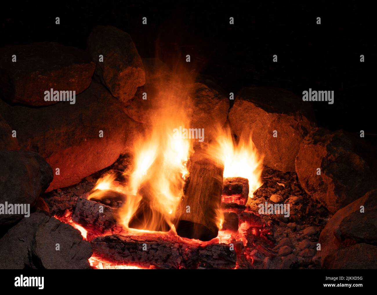 Campfire with a rock ring brightly glowing in the night Stock Photo - Alamy
