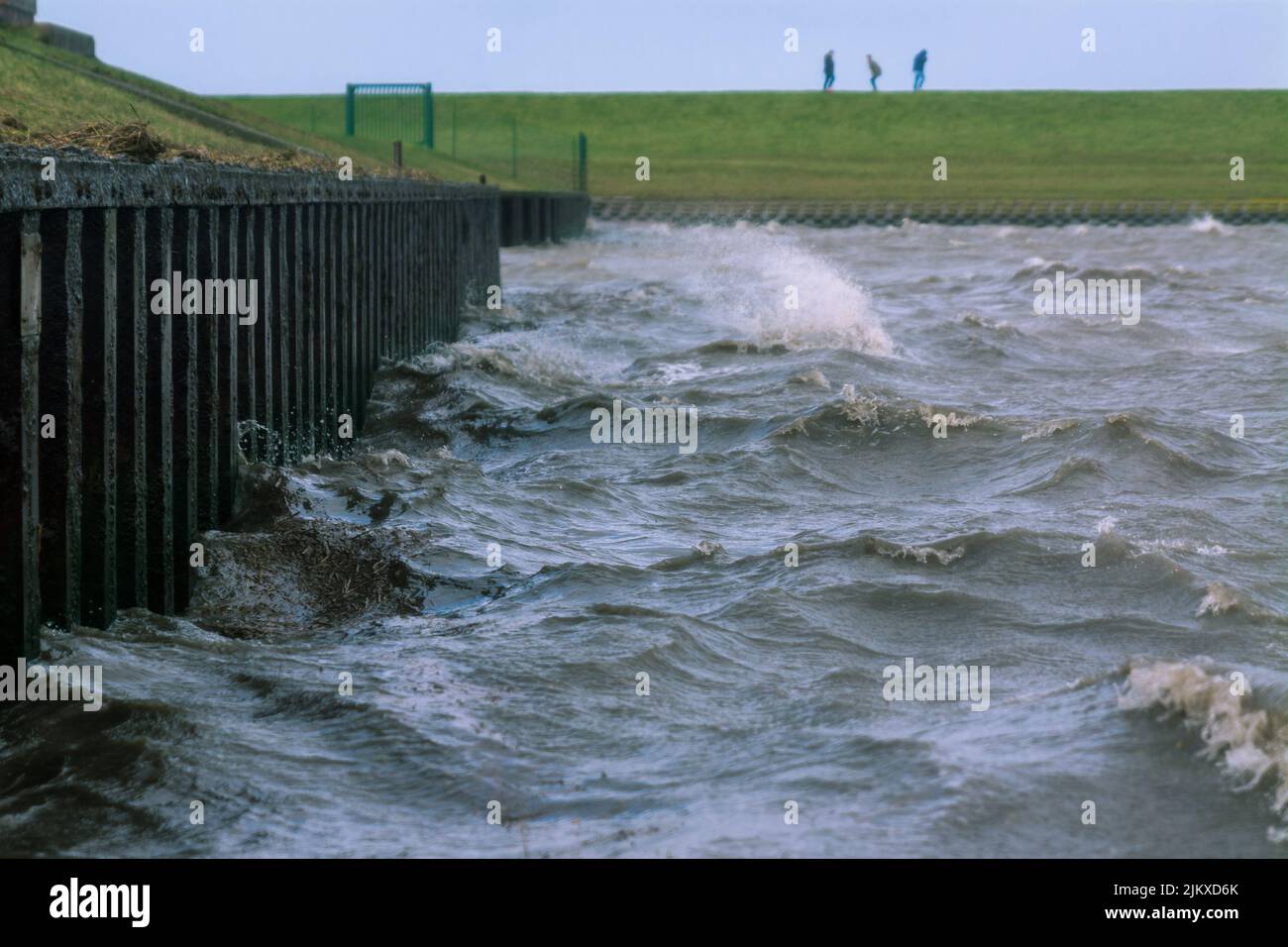 The waves of the river touching the metal breakwater over a blurry ...