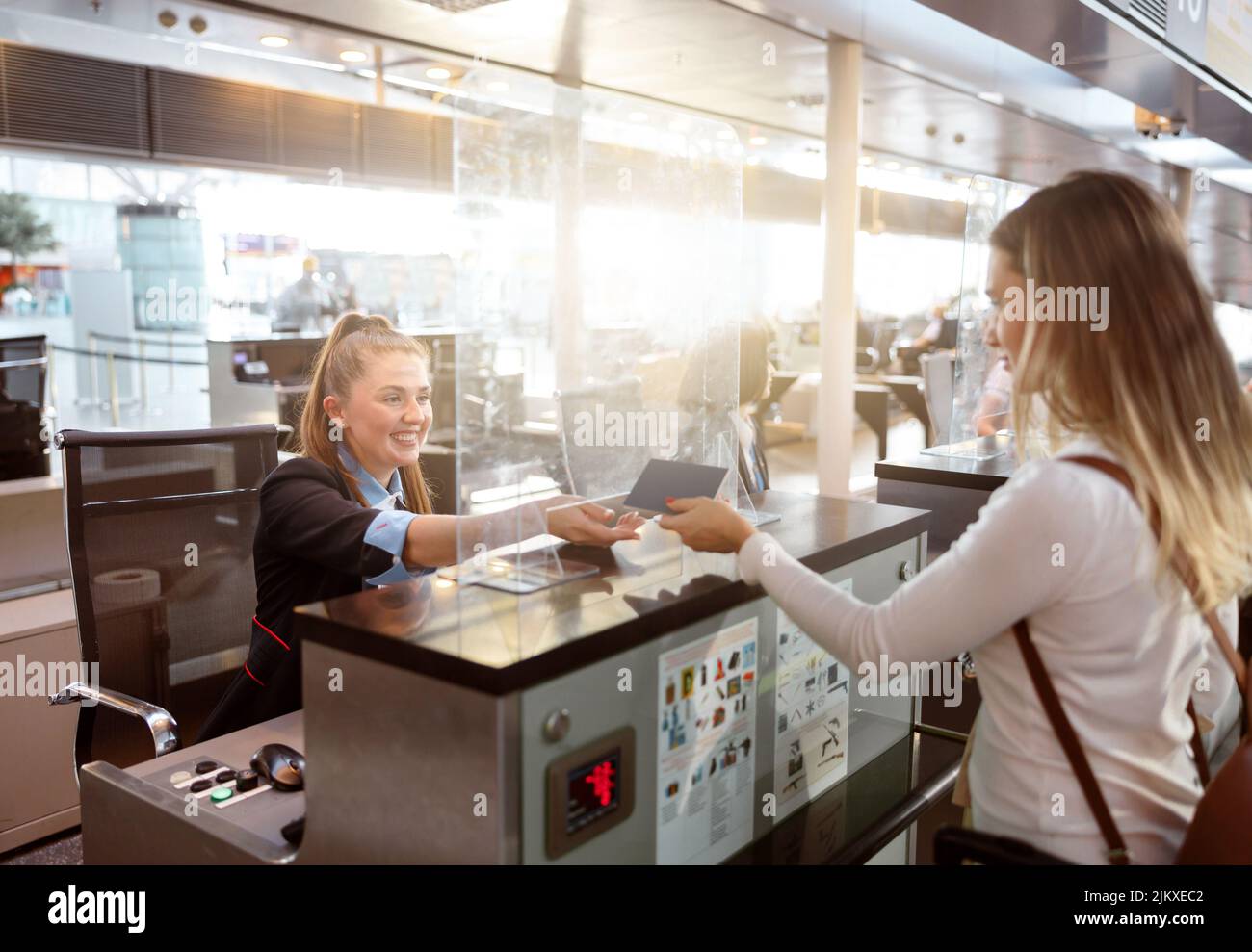 Female passenger checking in at airline counter Stock Photo - Alamy
