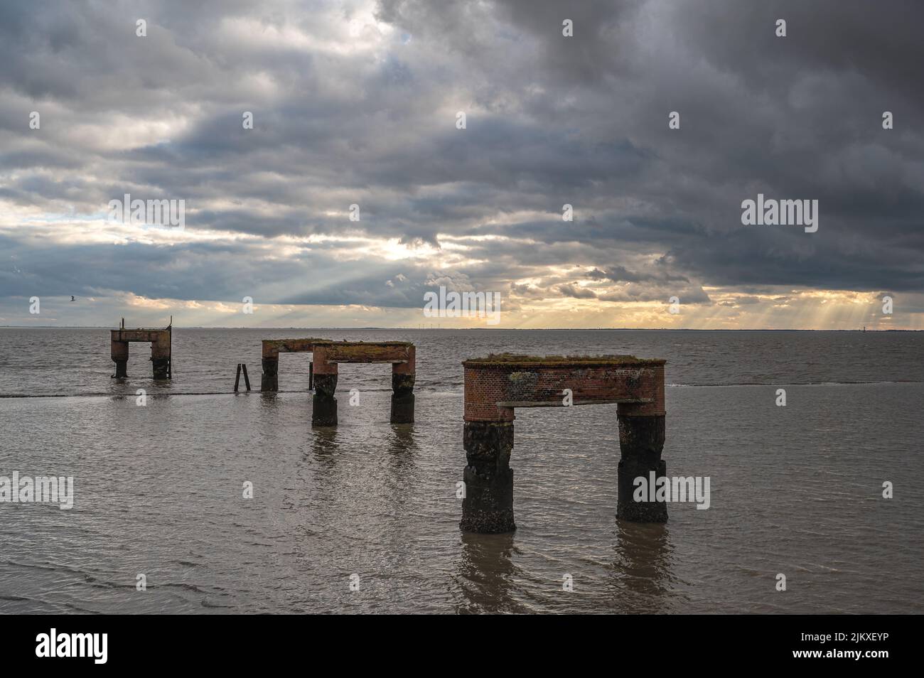 The beautiful sea under a cloudy sky with bridge ruins in it, Germany ...