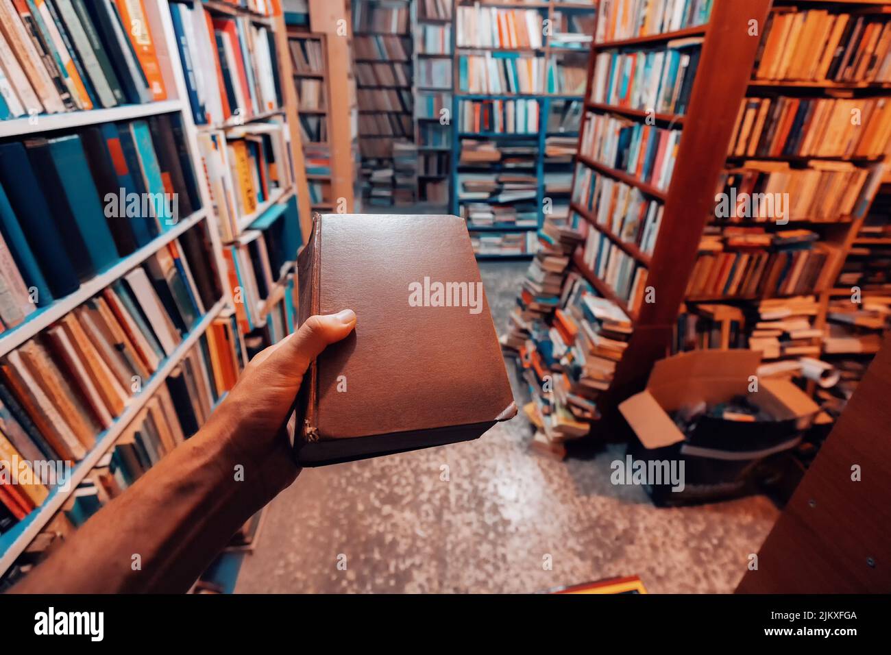 An old book volume of an ancient edition in hand in the interior of the ...