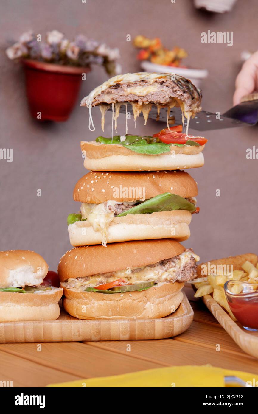 A beautiful shot of two hamburgers with a huge piece of meat and cheese ...
