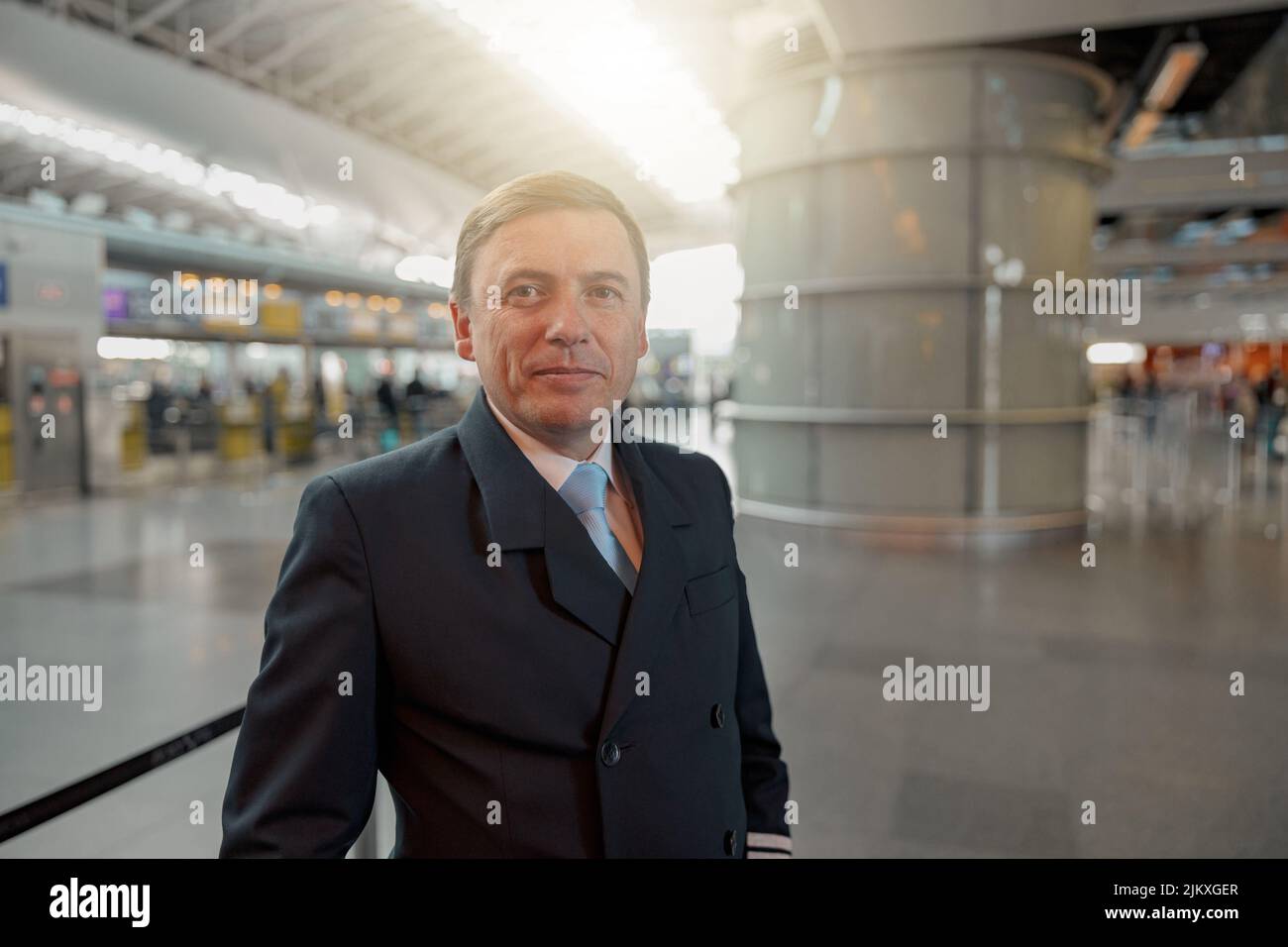 Mature male pilot standing at the airport terminal Stock Photo - Alamy