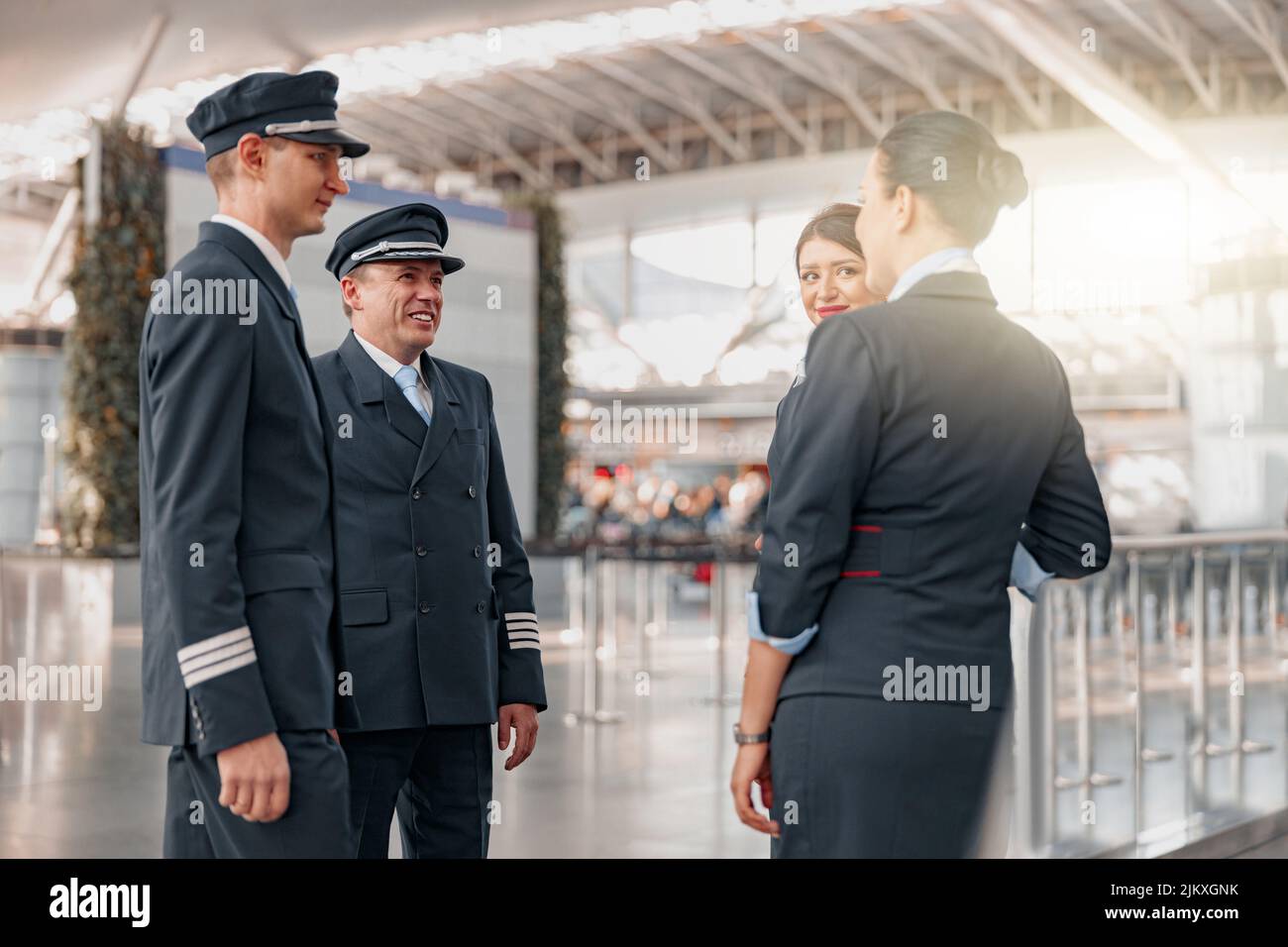 Happy plane team standing and talking in airport terminal Stock Photo ...