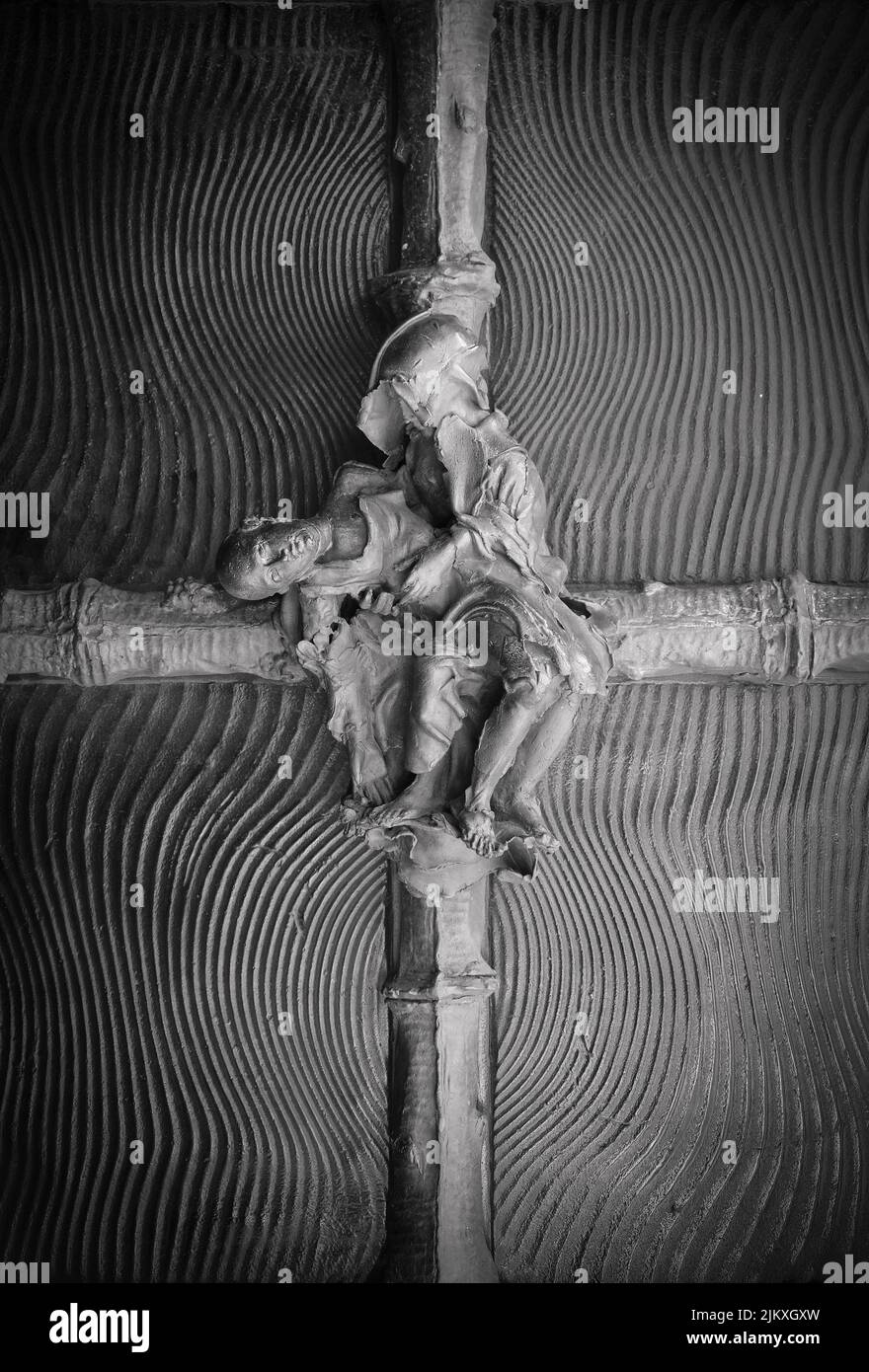 A vertical grayscale closeup of the church door decoration. Crucifix ...