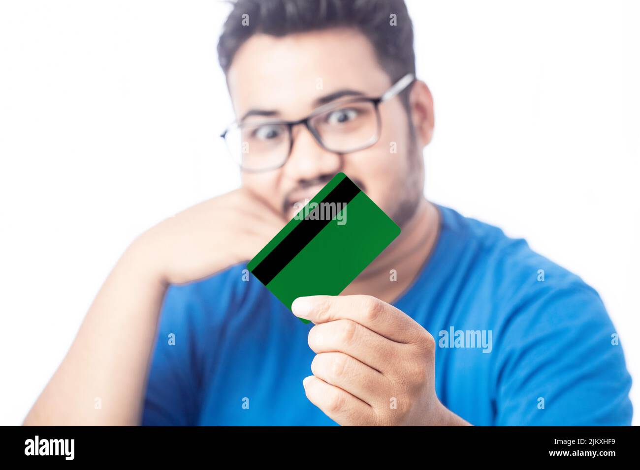 happy man showing debit card towards camera on a blurred background ...