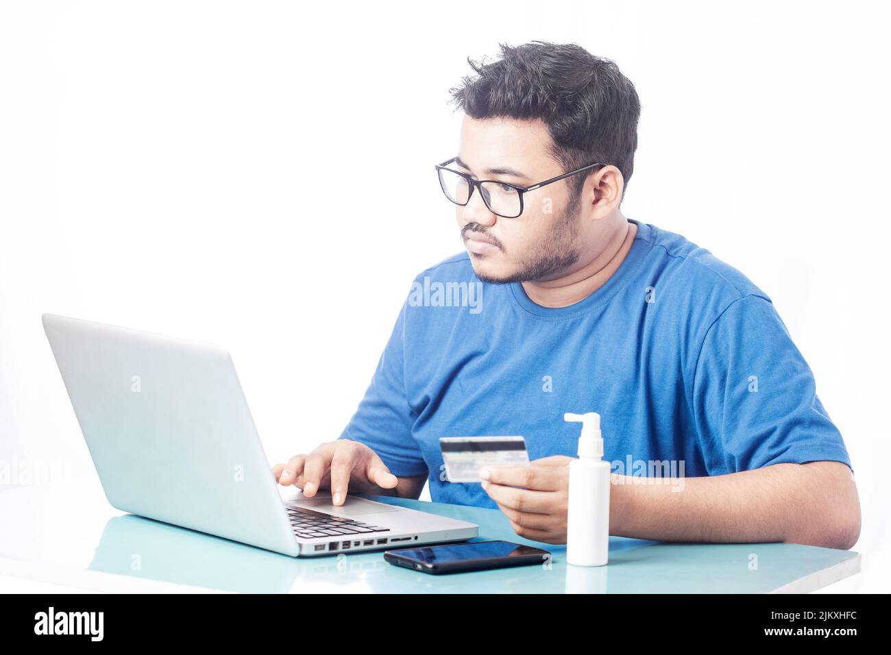 young man using debit card and laptop for online bill payment Stock ...