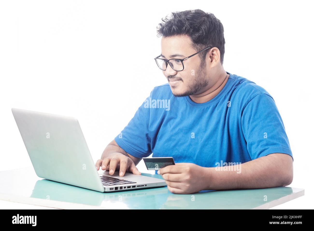 happy young man making online transaction using debit card and laptop ...