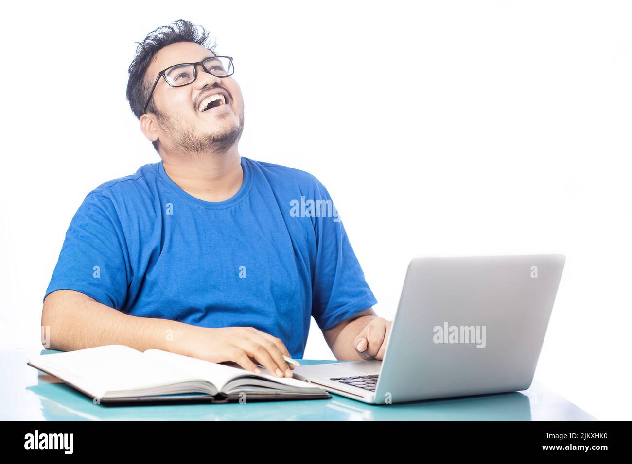 male student laughing when talking on video calling in white background ...