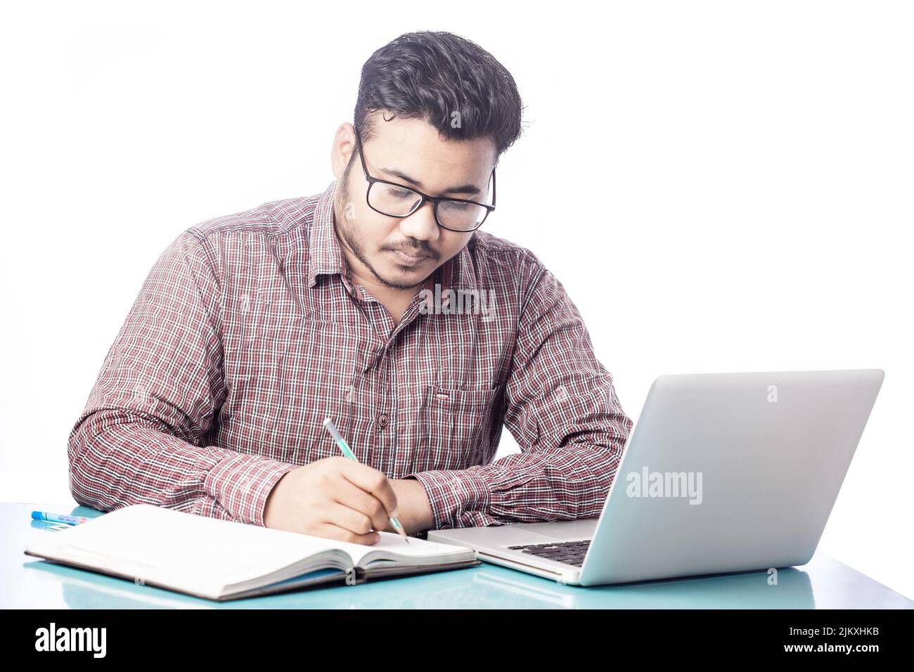 corporate man writing on notebook diary with pencil using laptop on ...