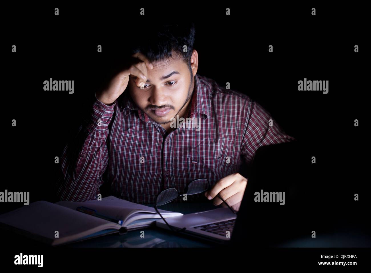 Tensed young businessman using laptop hi-res stock photography and ...