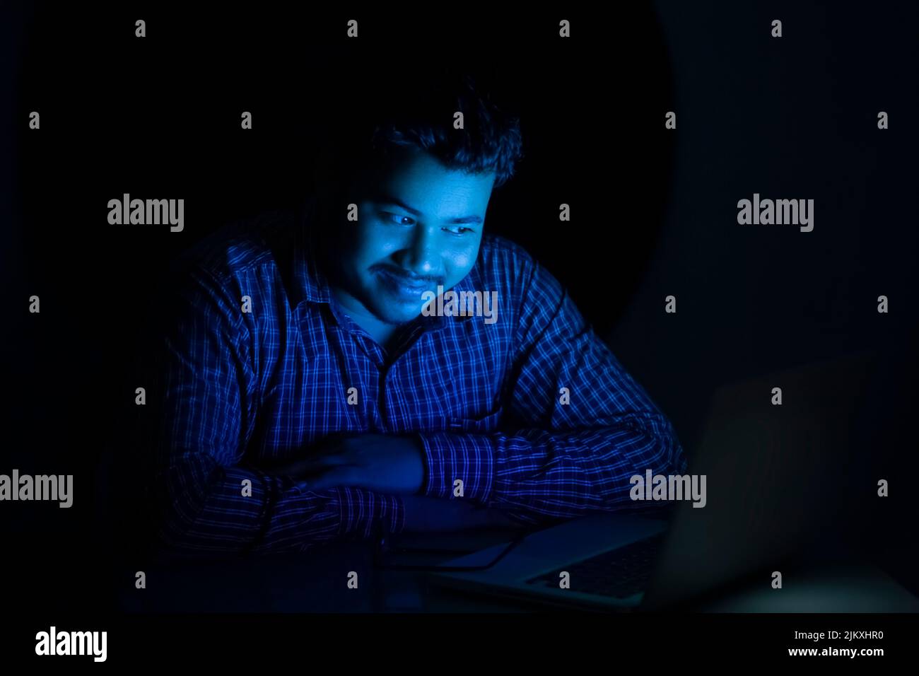 young man watching something on laptop at late night Stock Photo - Alamy