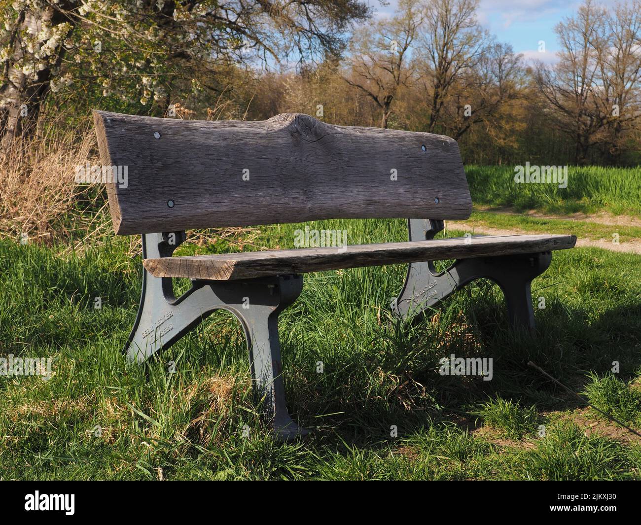 Bench made out of solid wood and iron placed next to a hiking trail ...