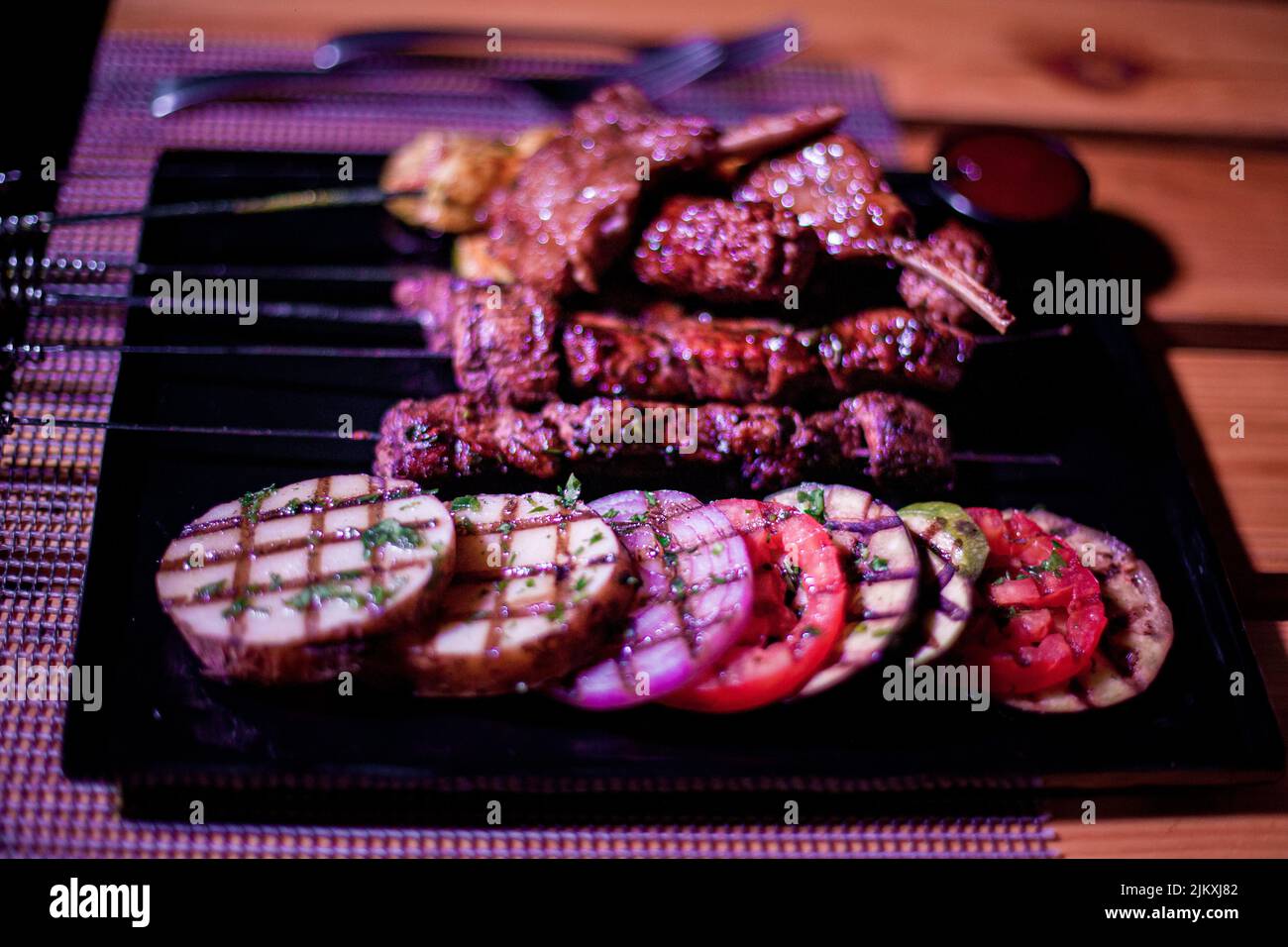 A plate of Chicken and beef BBQ with grilled tomatoes, potatoes and ...