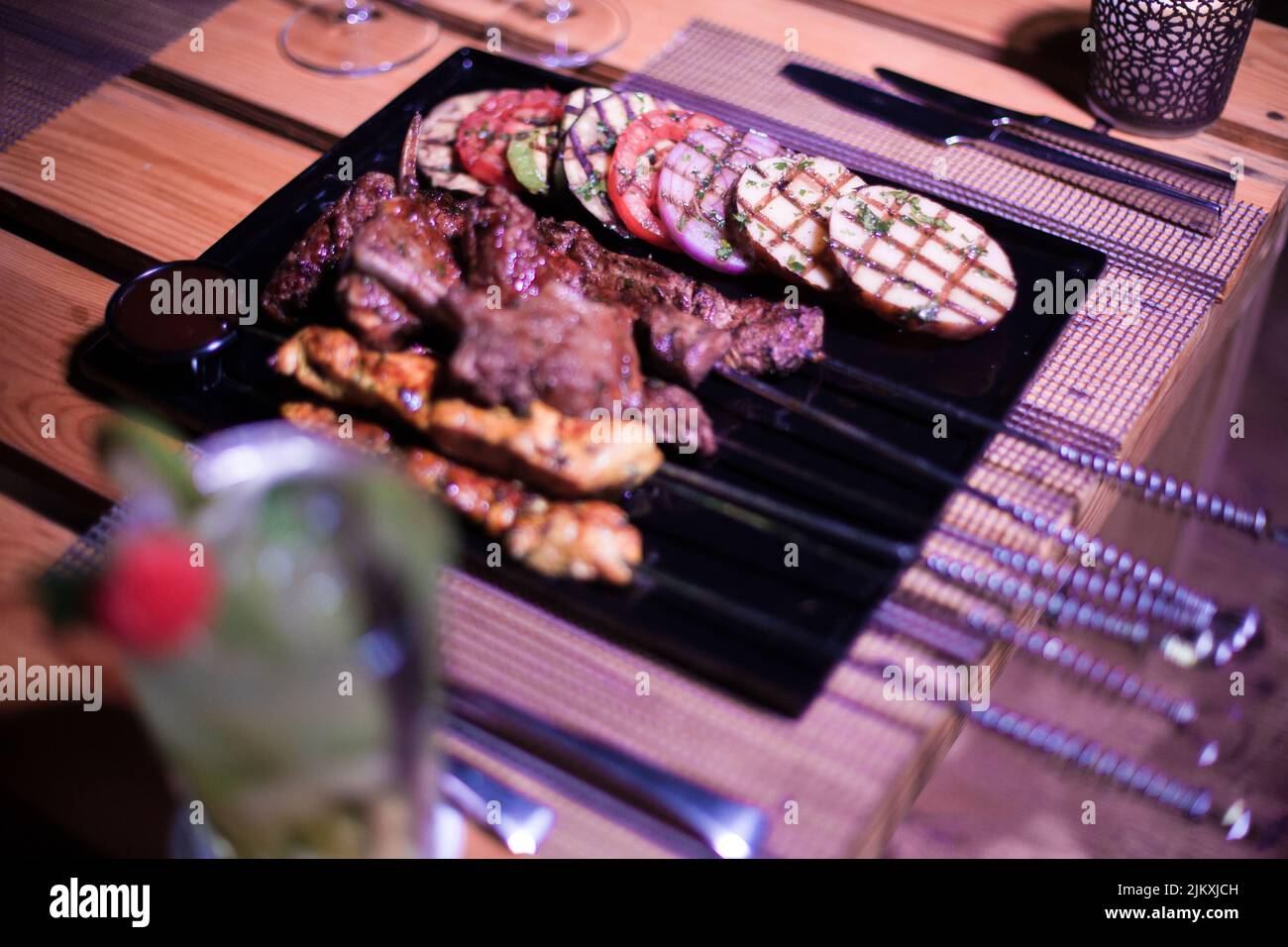 A plate of Chicken and beef BBQ with grilled tomatoes, potatoes and ...