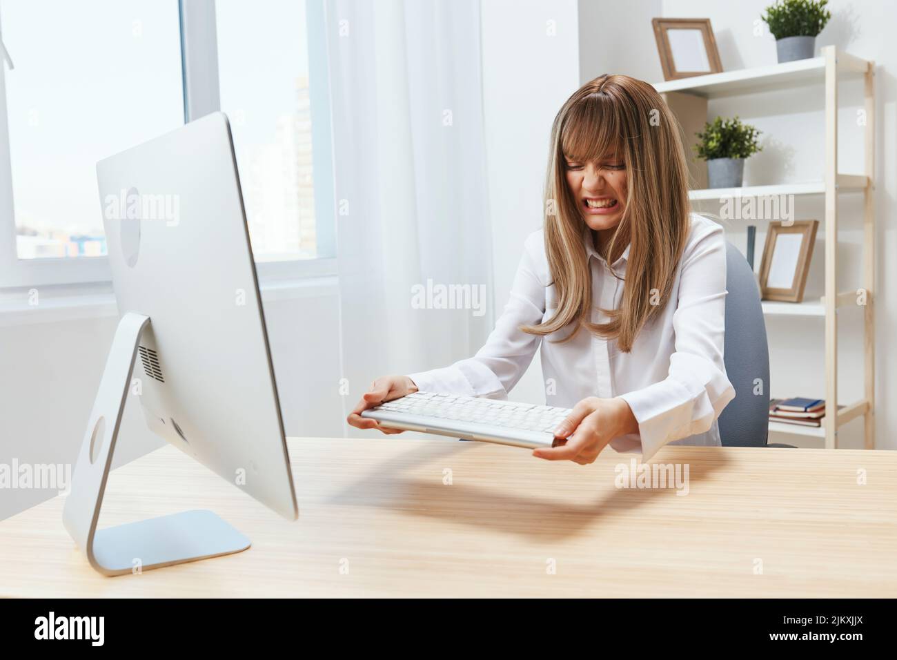 Irritated blonde businesswoman screaming to keyboard Raging after ...