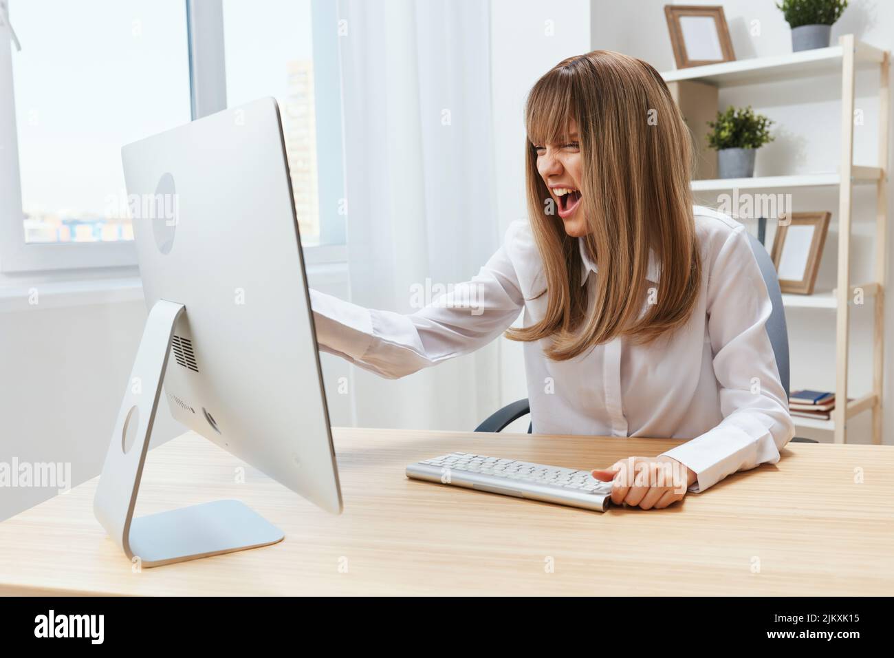 Angry evil blonde businesswoman screaming to desktop Raging after ...