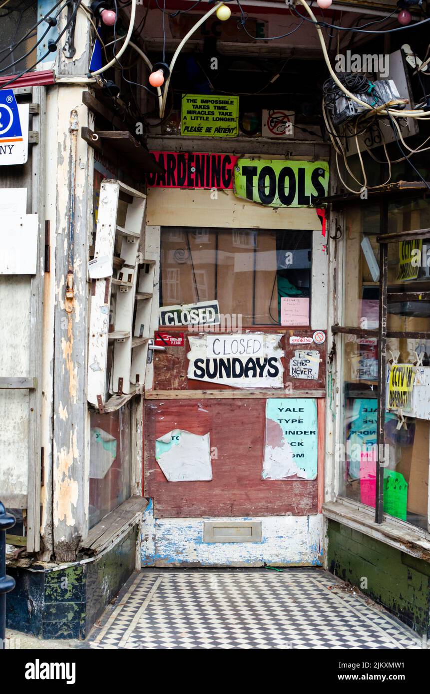 An old fashioned hardware store with multiple bright and torn signs ...