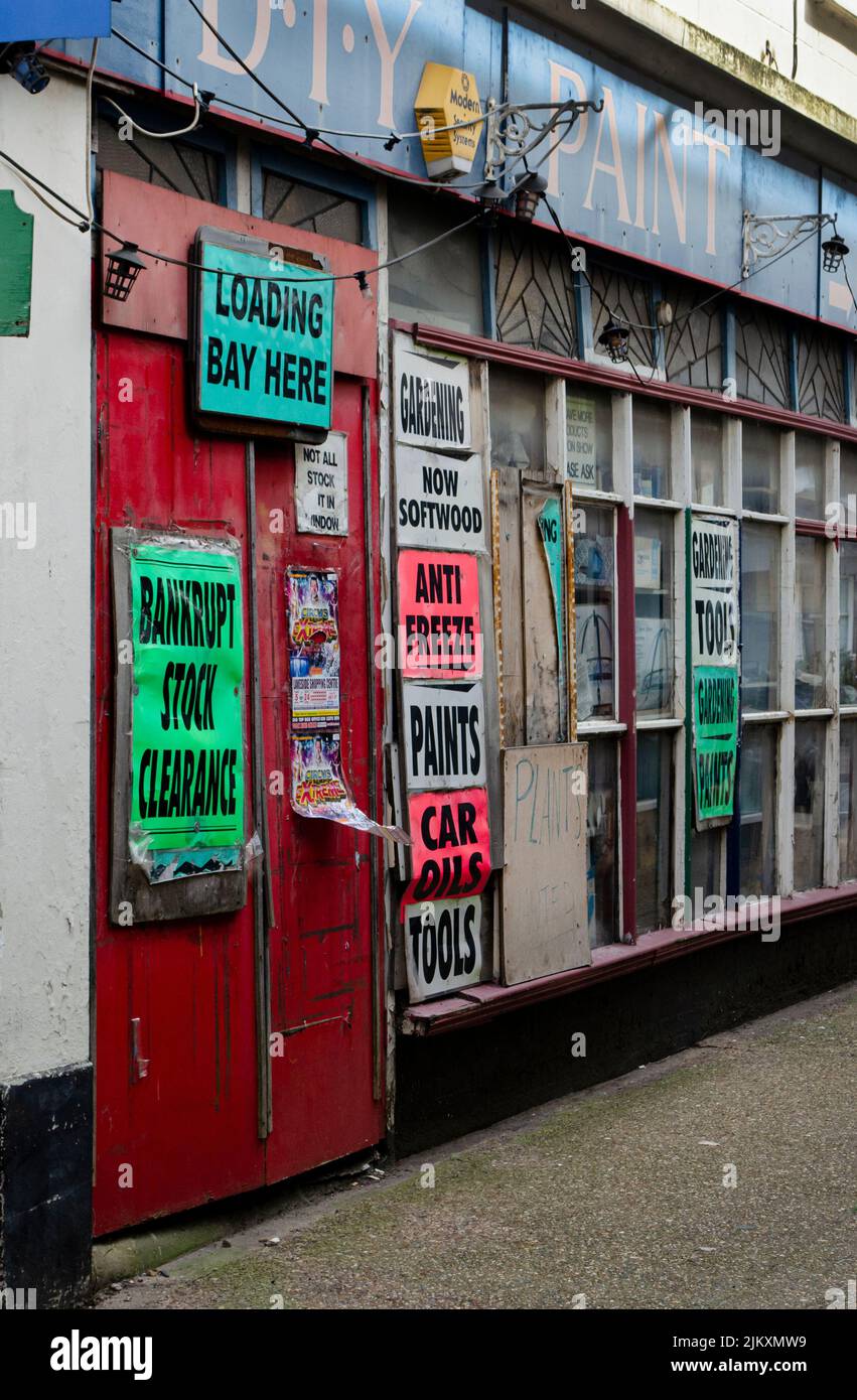 An old fashioned hardware store with multiple bright and torn signs ...